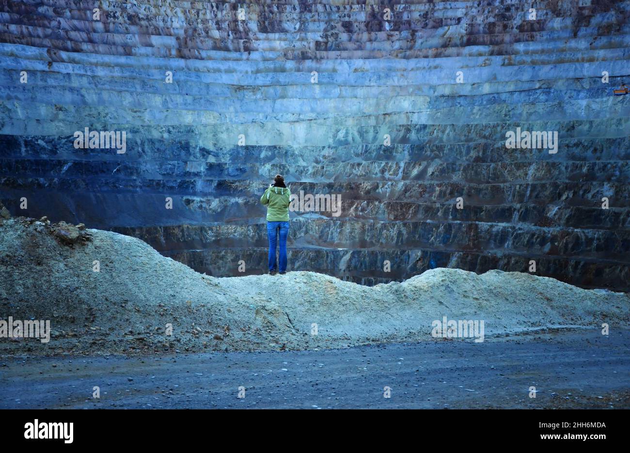 Geologist studying gigantic open cast gold and copper mine terraces ...