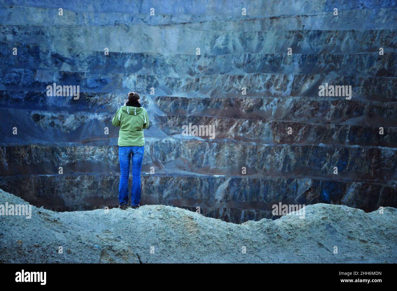 Geologist studying gigantic open cast gold and copper mine terraces ...