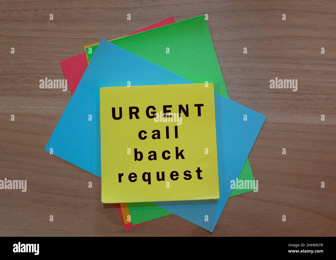 Urgent call back request text on colorful notepad on wooden background ...