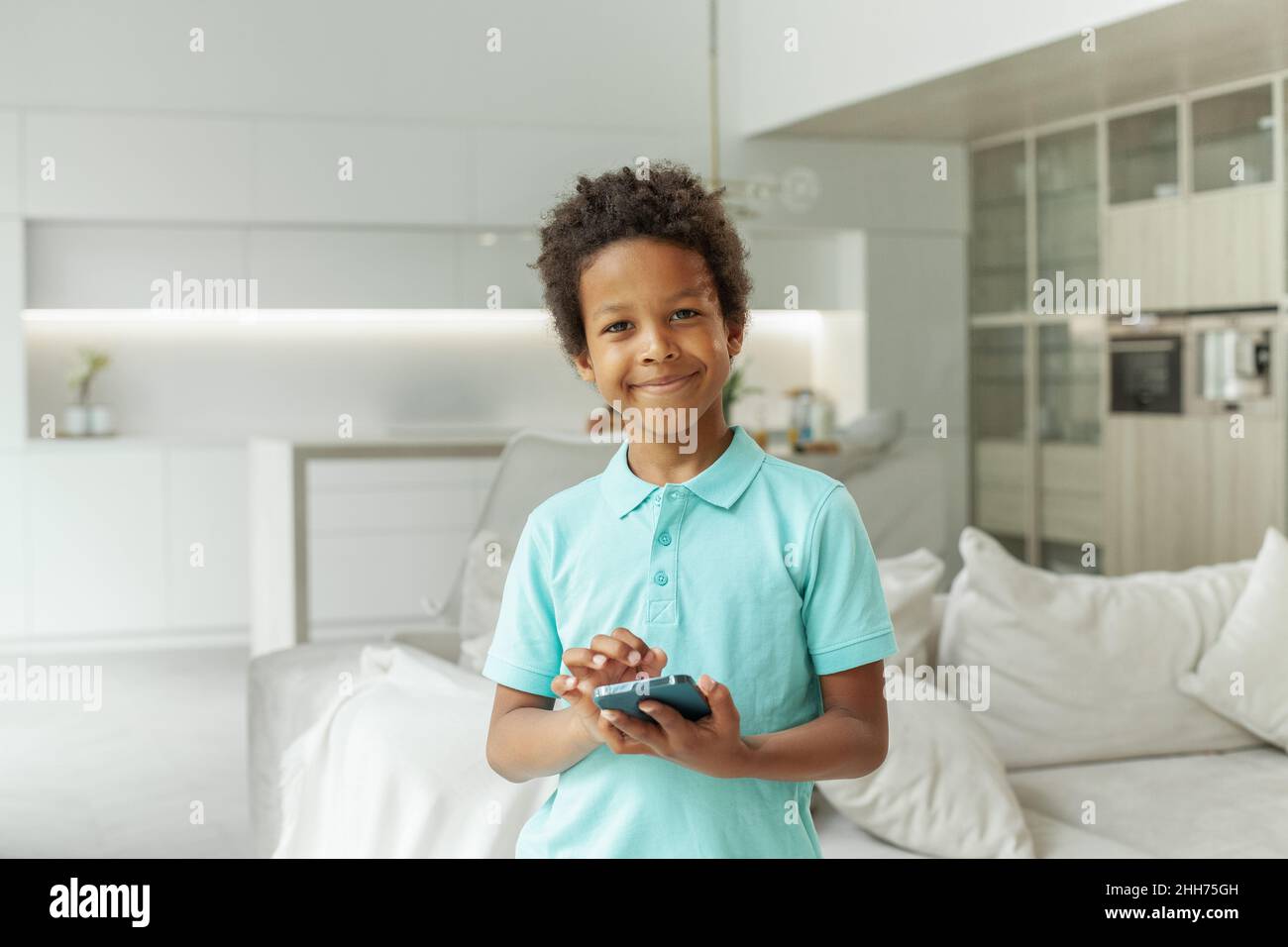 Smiling child boy with phone at home Stock Photo - Alamy