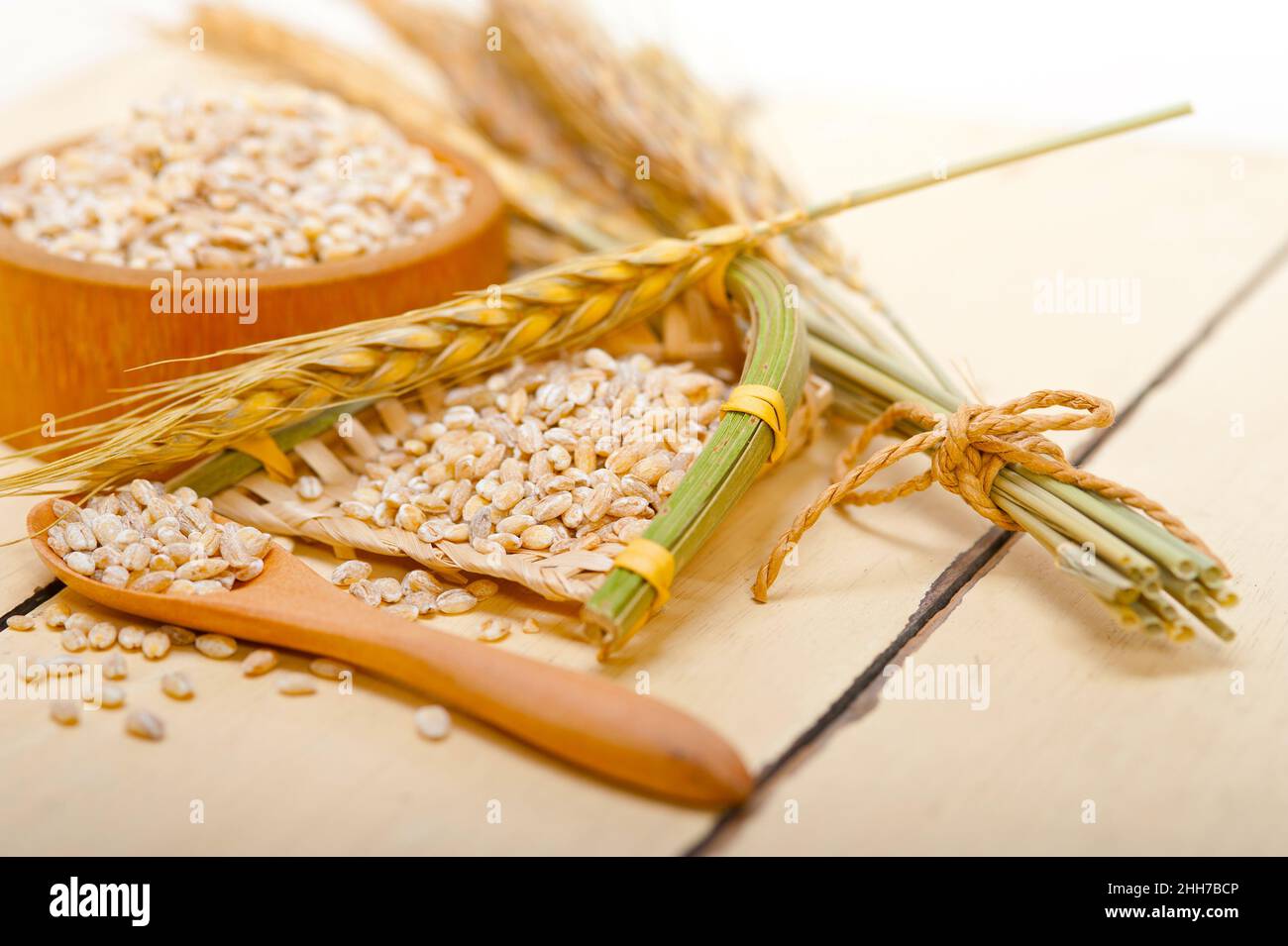 organic wheat grains over rustic wood table macro closeup Stock Photo ...