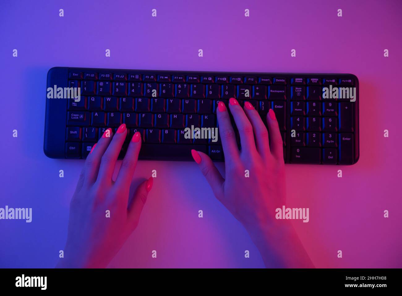 Hand in neon light typing hi-res stock photography and images - Alamy