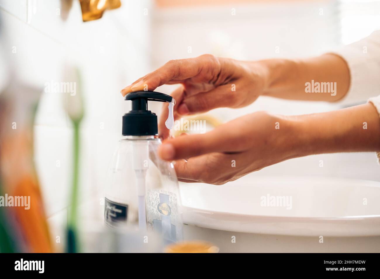 Woman using soap dispenser indoors, closeup view Stock Photo - Alamy