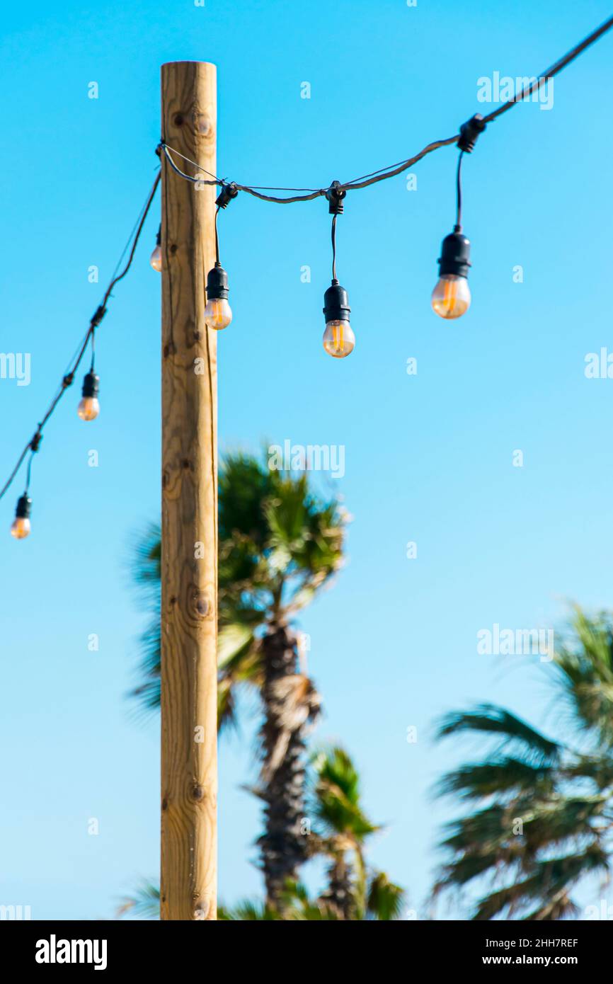Line of light bulbs lighting the way to a terrace on the beach Stock ...
