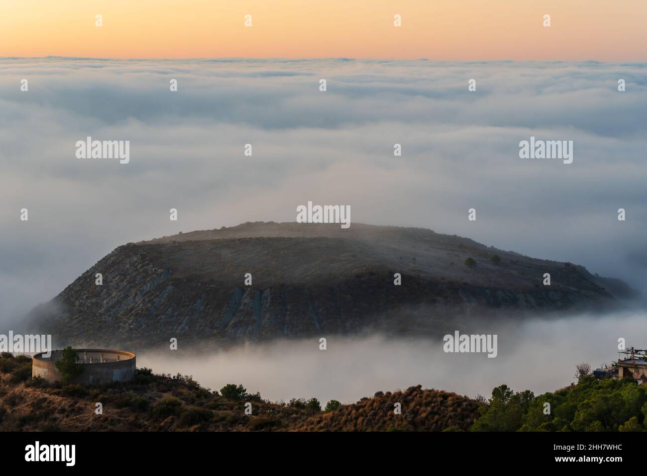 Landscape with very low clouds creating a white sea, with a mountain ...