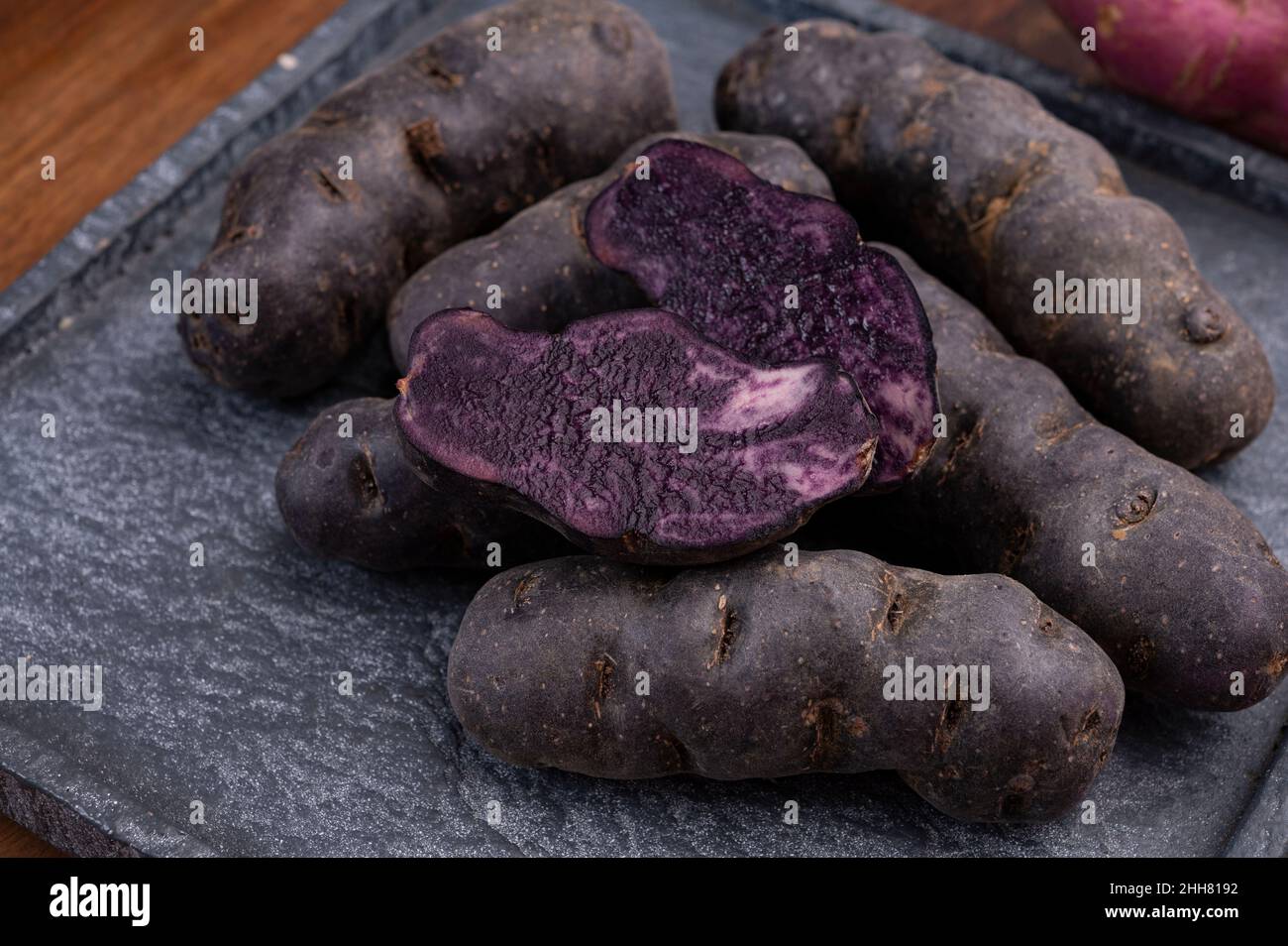 Colorful belgian purple or black truffle potato root vegetable ready to ...