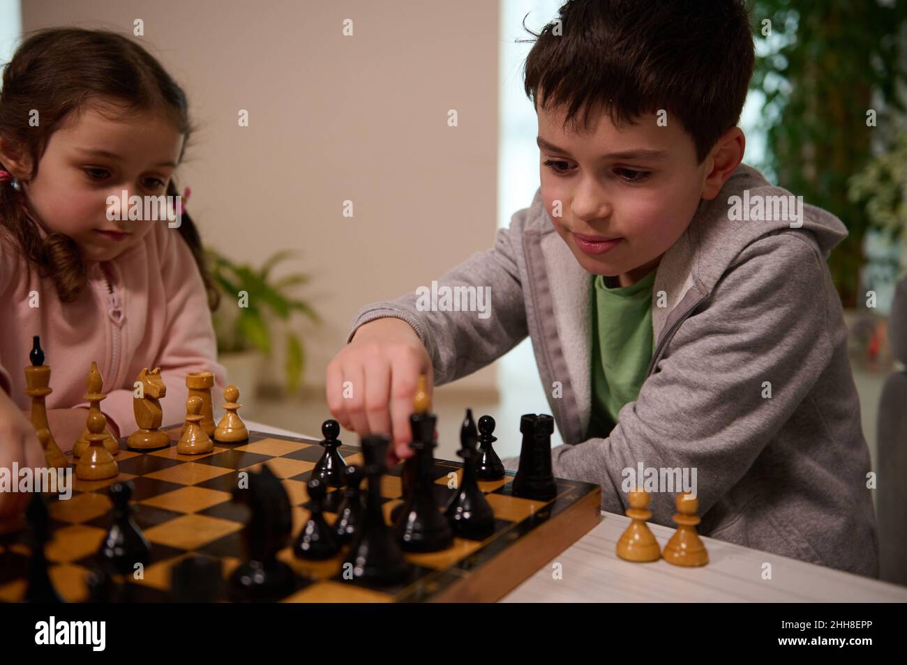 A chess game for a clever mind. Beautiful smart kids playing chess ...