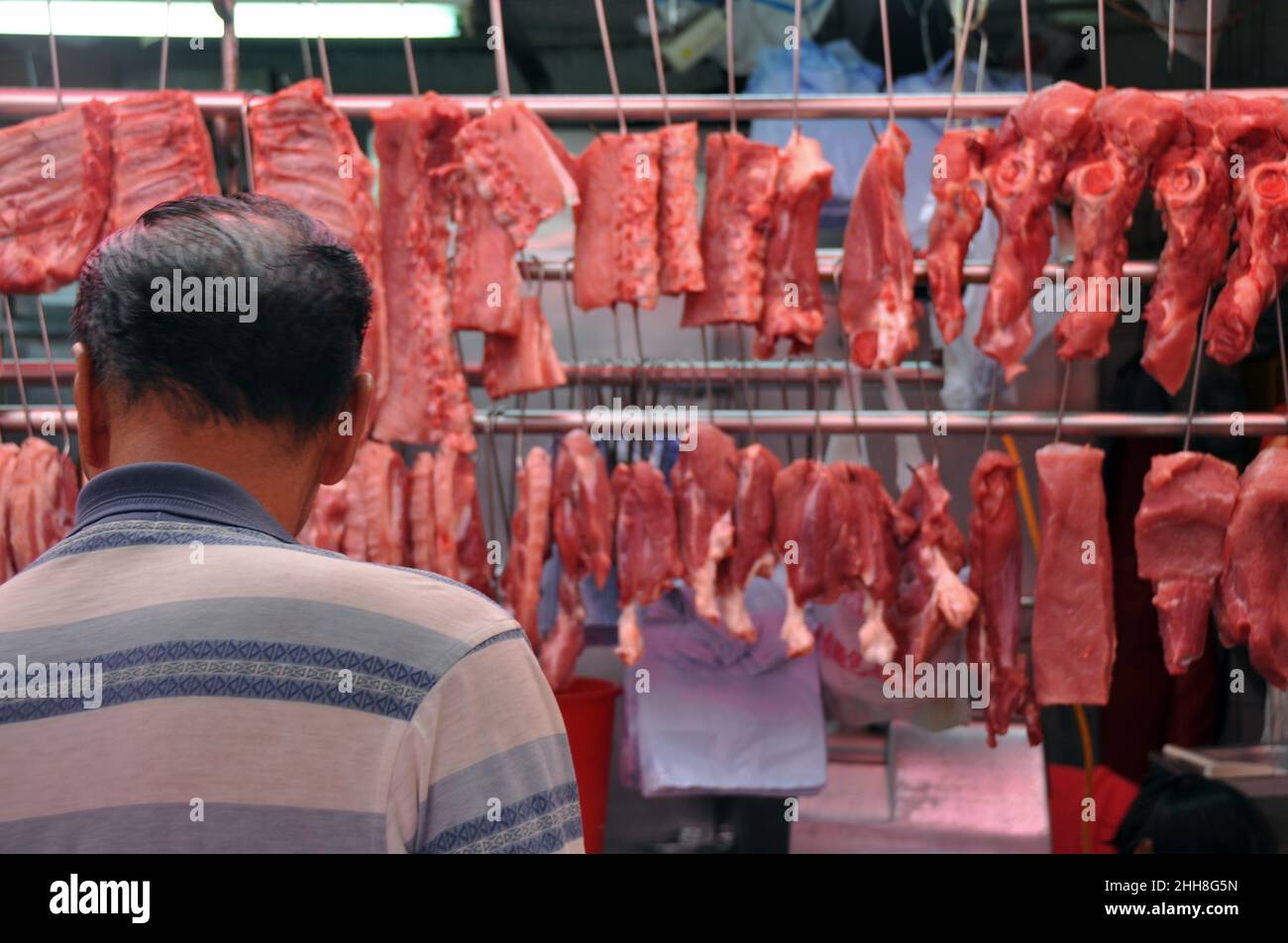 A customer browsing the fresh cuts of meat on display for the day in ...