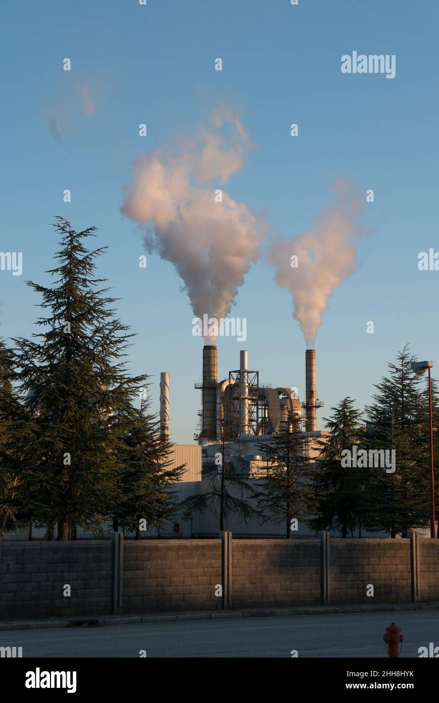 Chimneys of a factory releasing smoke from the production in the air ...
