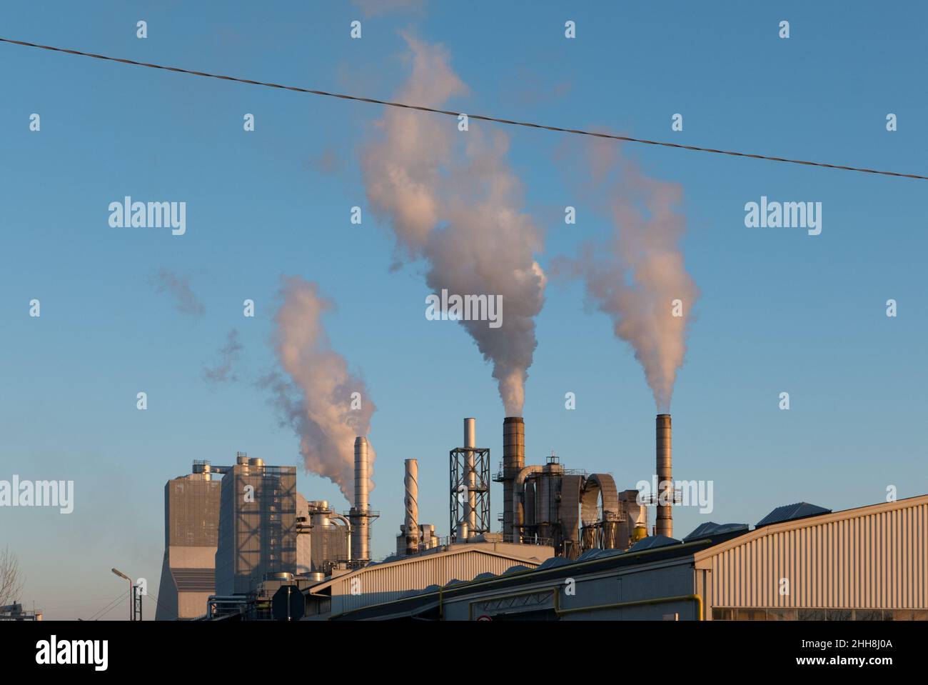 Chimneys of a factory releasing smoke from the production in the air ...