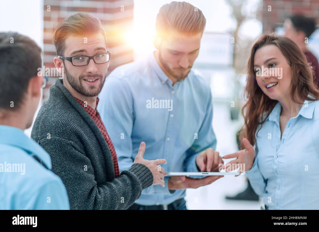 Beautiful business people are using gadget, talking and smiling while ...
