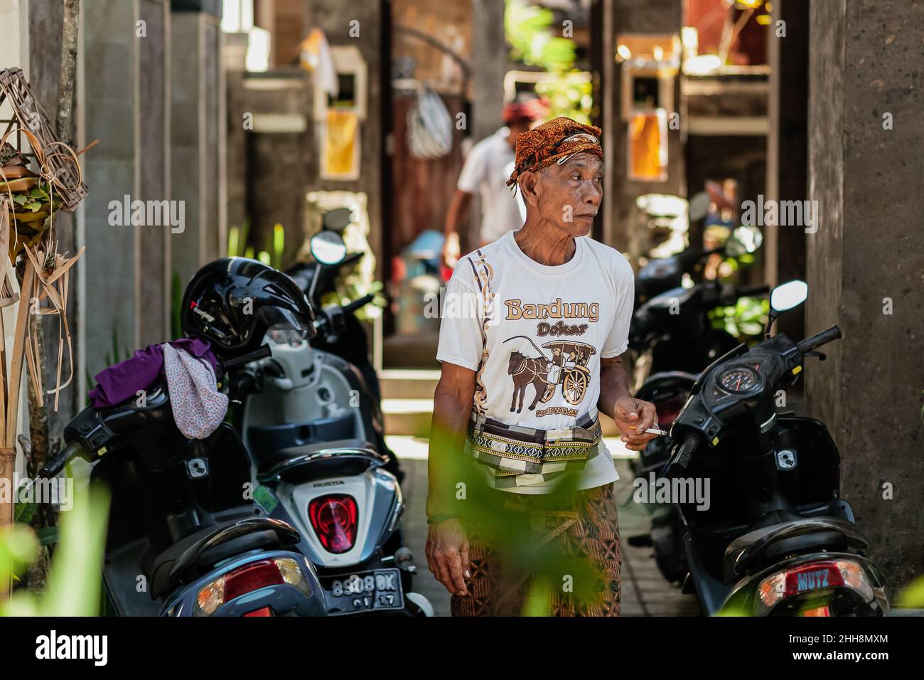 BALI, INDONESIA - MARCH 2, 2014: An old Balinese man walks with a ...