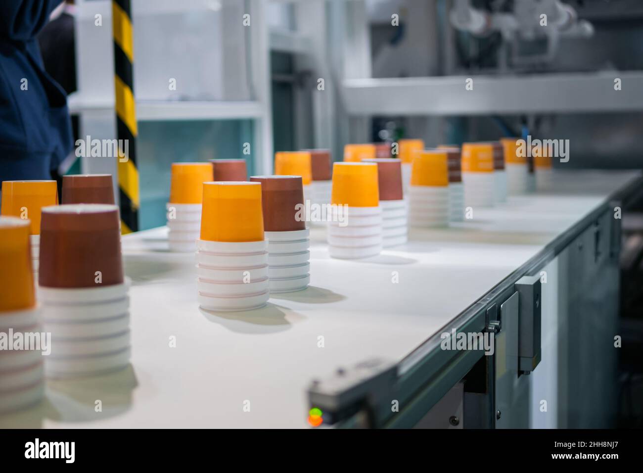Empty plastic cups moving on conveyor belt at package exhibition Stock ...