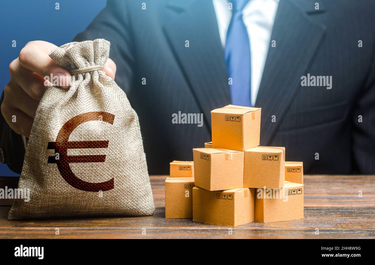 Businessman holds euro money bag and boxes with goods. Purchase and sale of goods, trade and ...