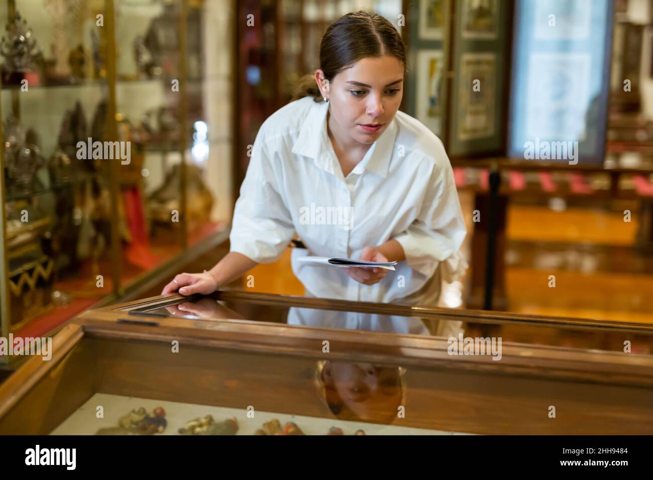 Young woman with information booklet visiting museum Stock Photo - Alamy