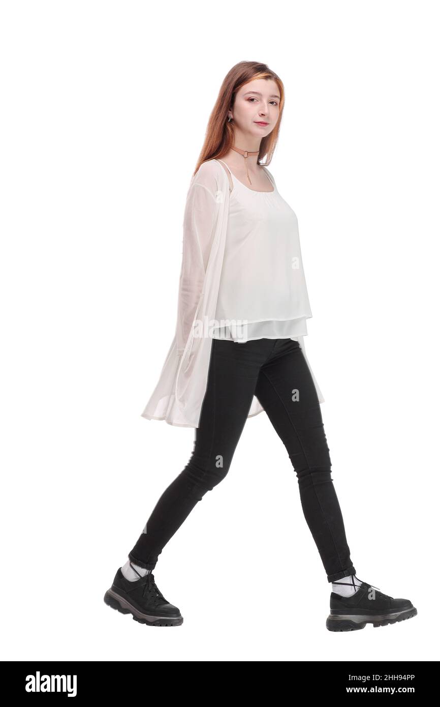 Side view of a casual young woman walking away from the camera and ...