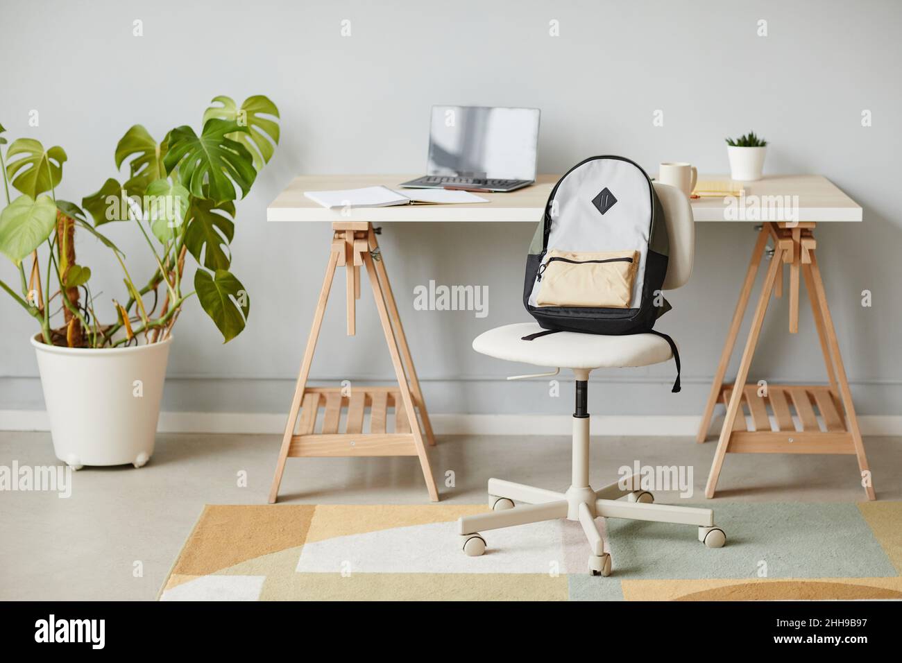 Minimal background image of school backpack by desk in home interior ...