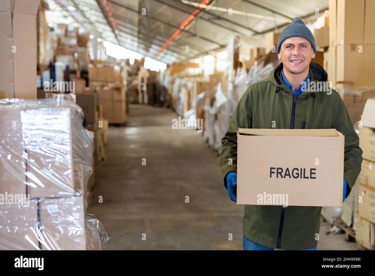 Loader stacks various boxes on racks in store Stock Photo - Alamy