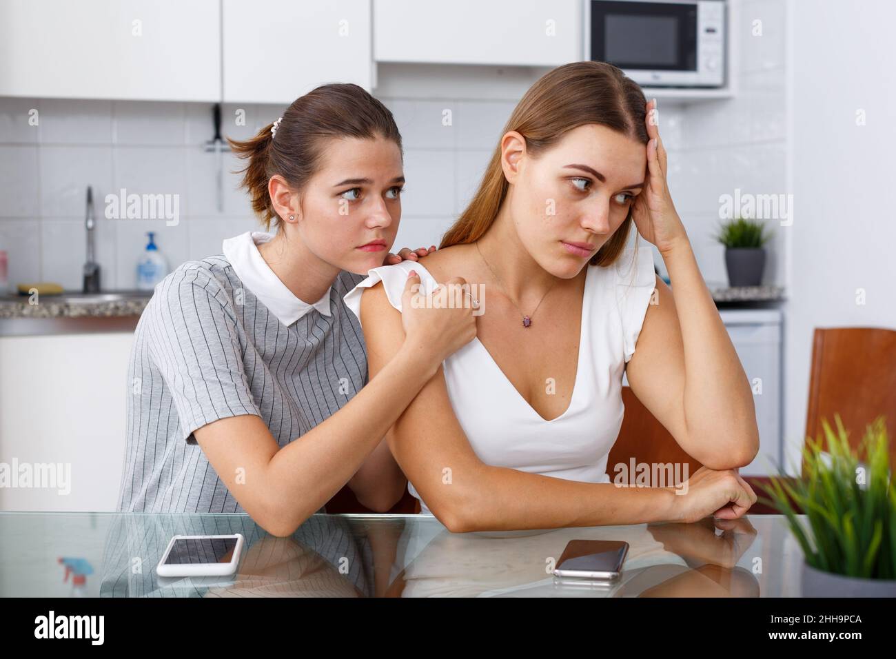 Girl calming her depressed friend Stock Photo - Alamy