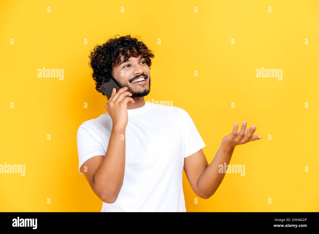 Phone talk by cellphone. Happy joyful excited Indian charismatic guy ...