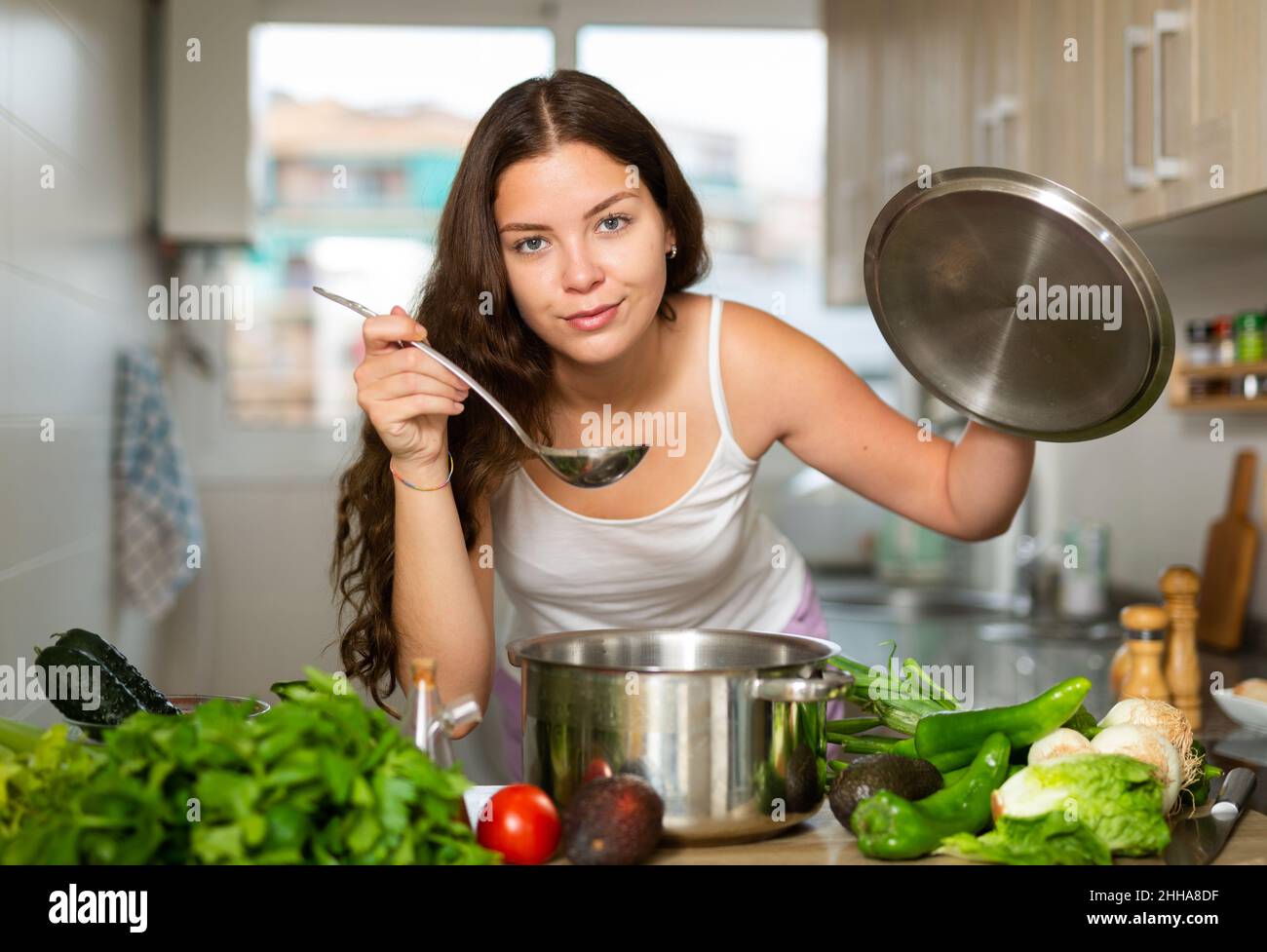 Woman holding cooking ladle spoon while cooking soup Stock Photo - Alamy