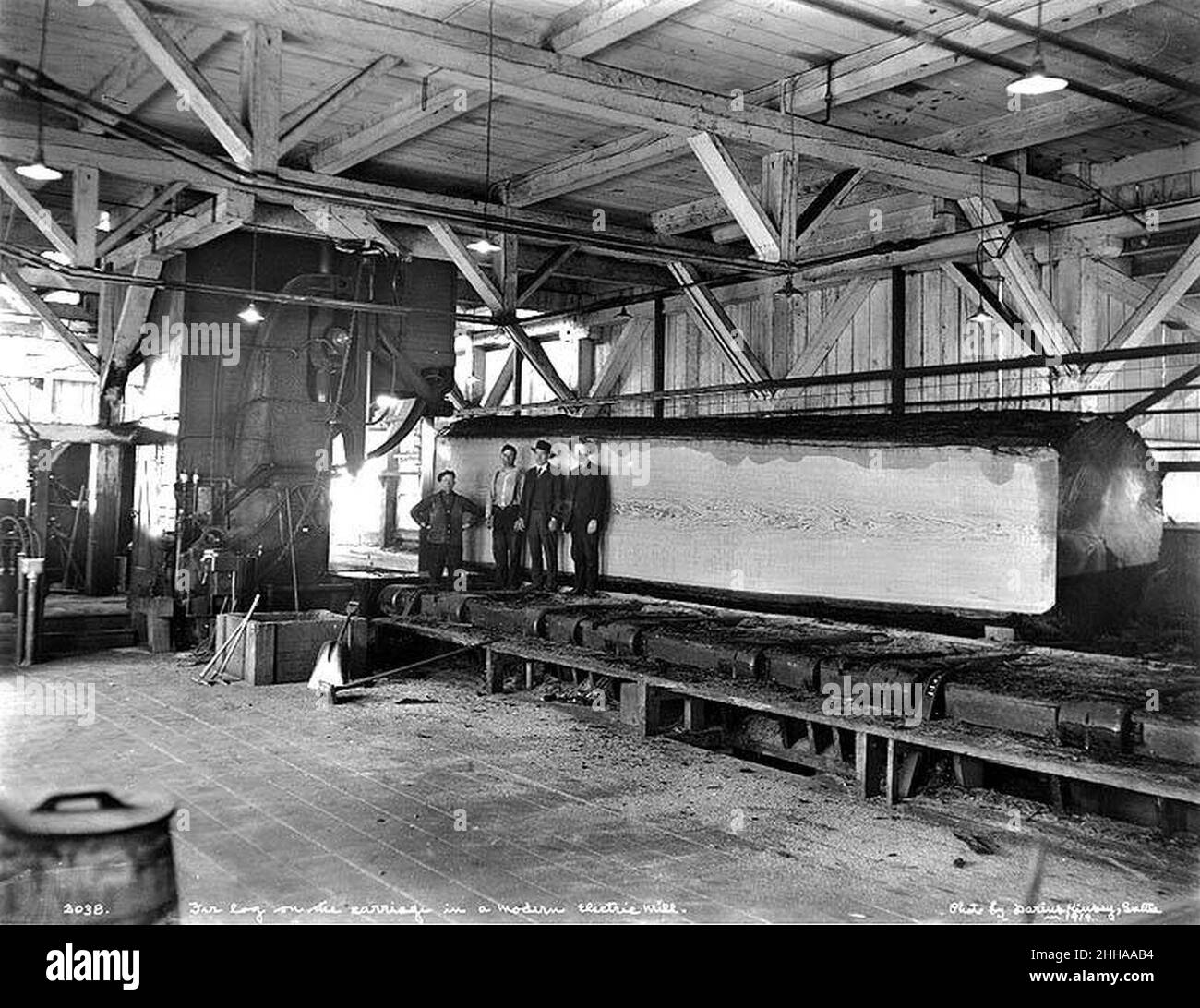 Snoqualmie Falls Lumber Co mill interior showing big log being cut be ...