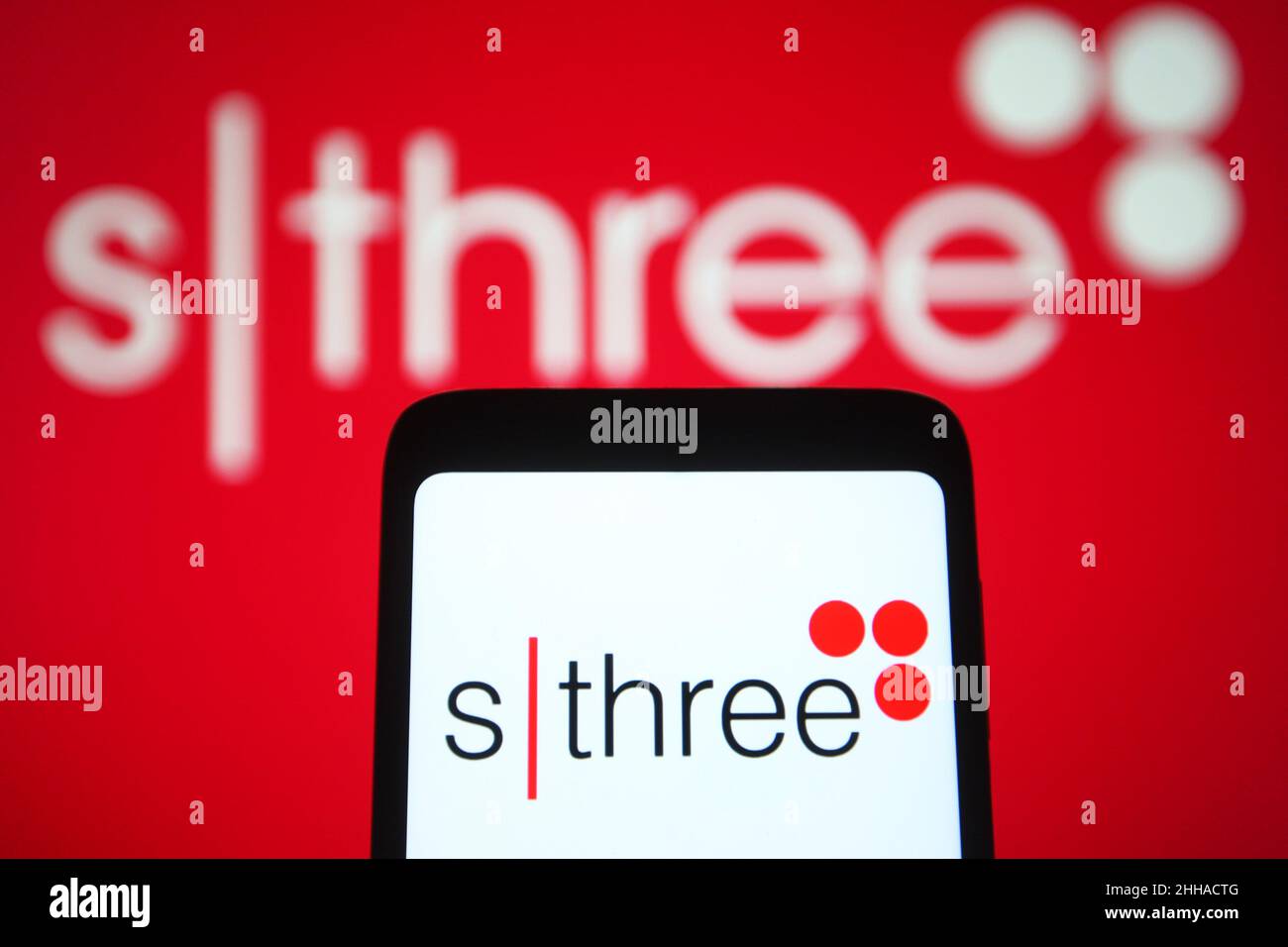 In this photo illustration, a SThree logo is seen on a smartphone and a ...