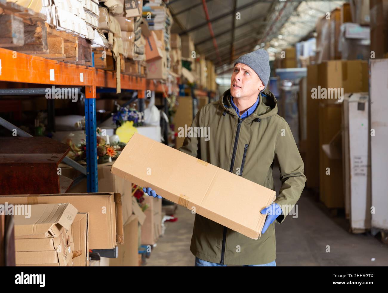 Man worker carrying cardboard box Stock Photo - Alamy
