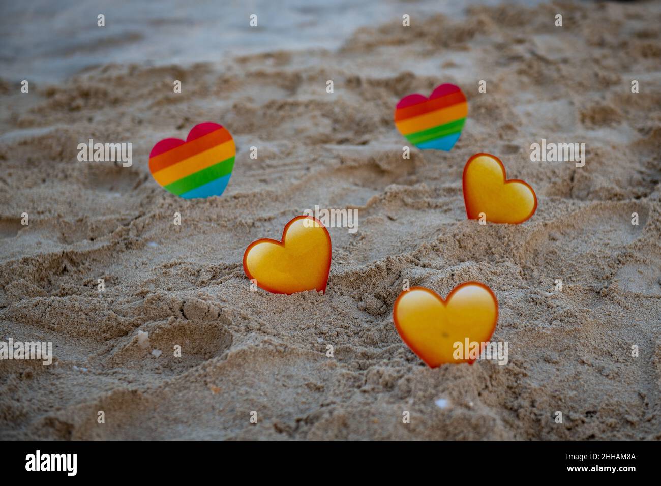 on the sea lgbt and yellow hearts in the sand stand Stock Photo - Alamy