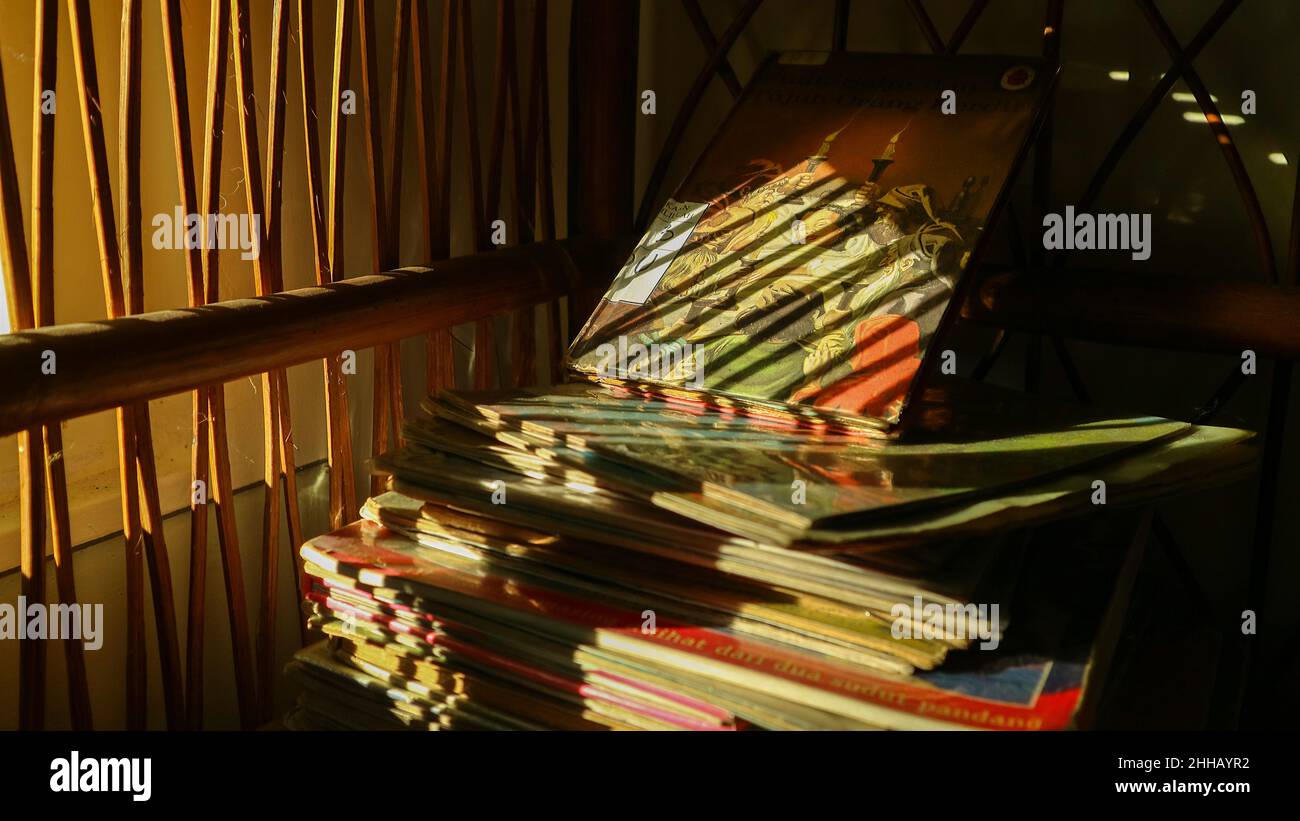 Pile of books in the library exposed to the sun Stock Photo - Alamy