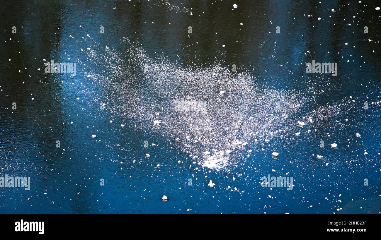 Winter abstract background. Snow hit the ice with a mighty splash. The ...