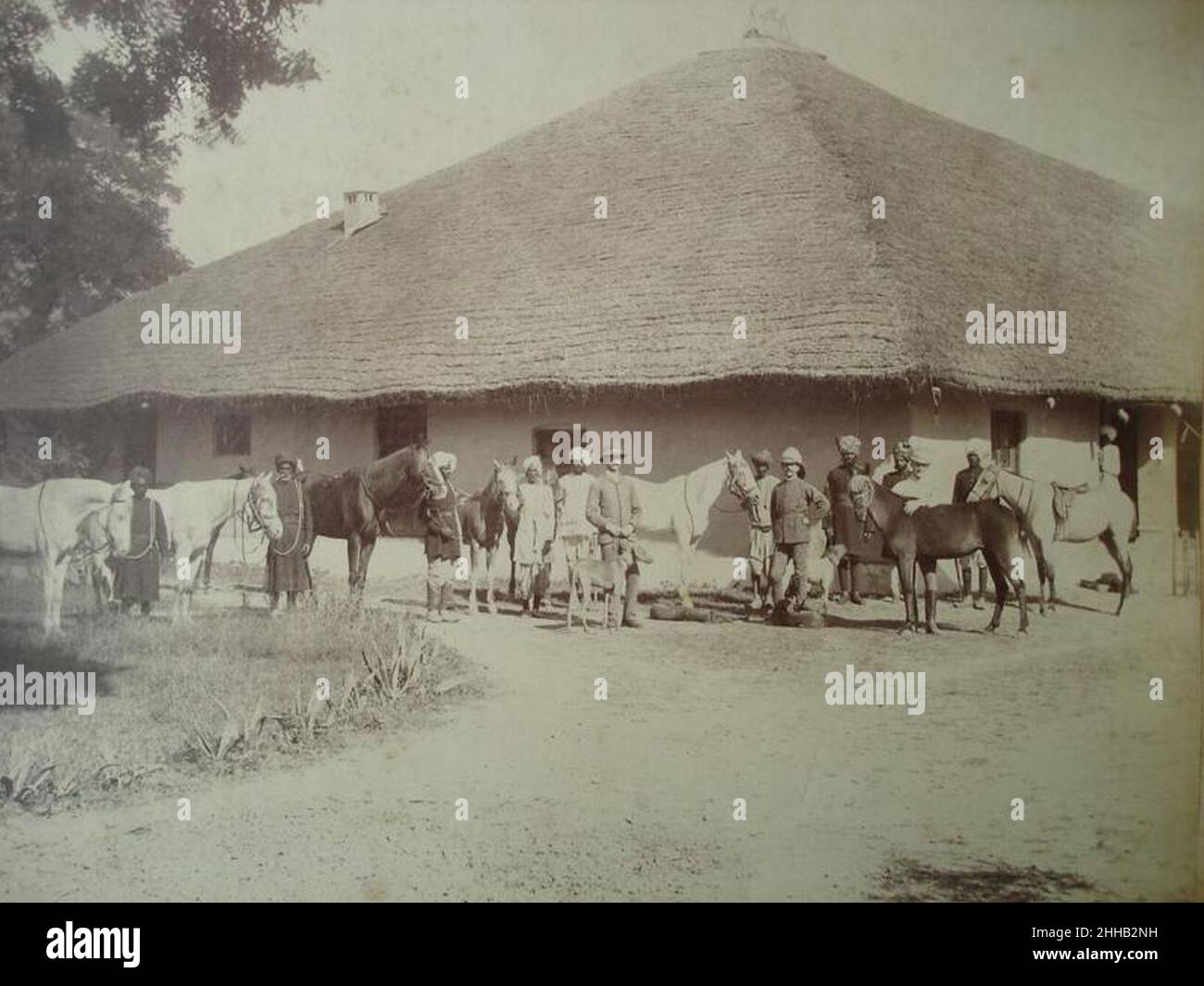 Soldiers with Indian servants in front of a thatched house in 1887 ...