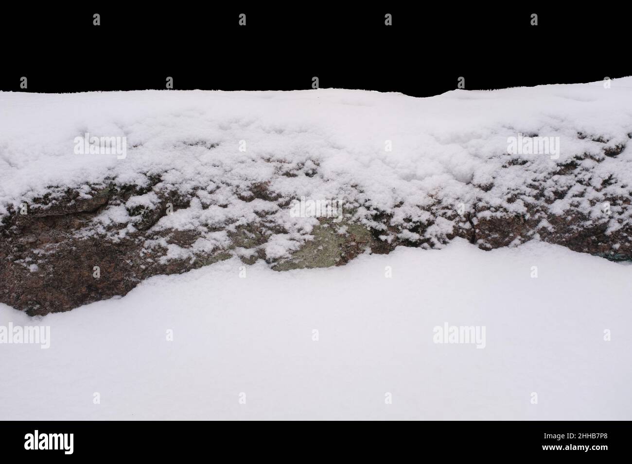 natural stone in snow isolated on black background Stock Photo - Alamy