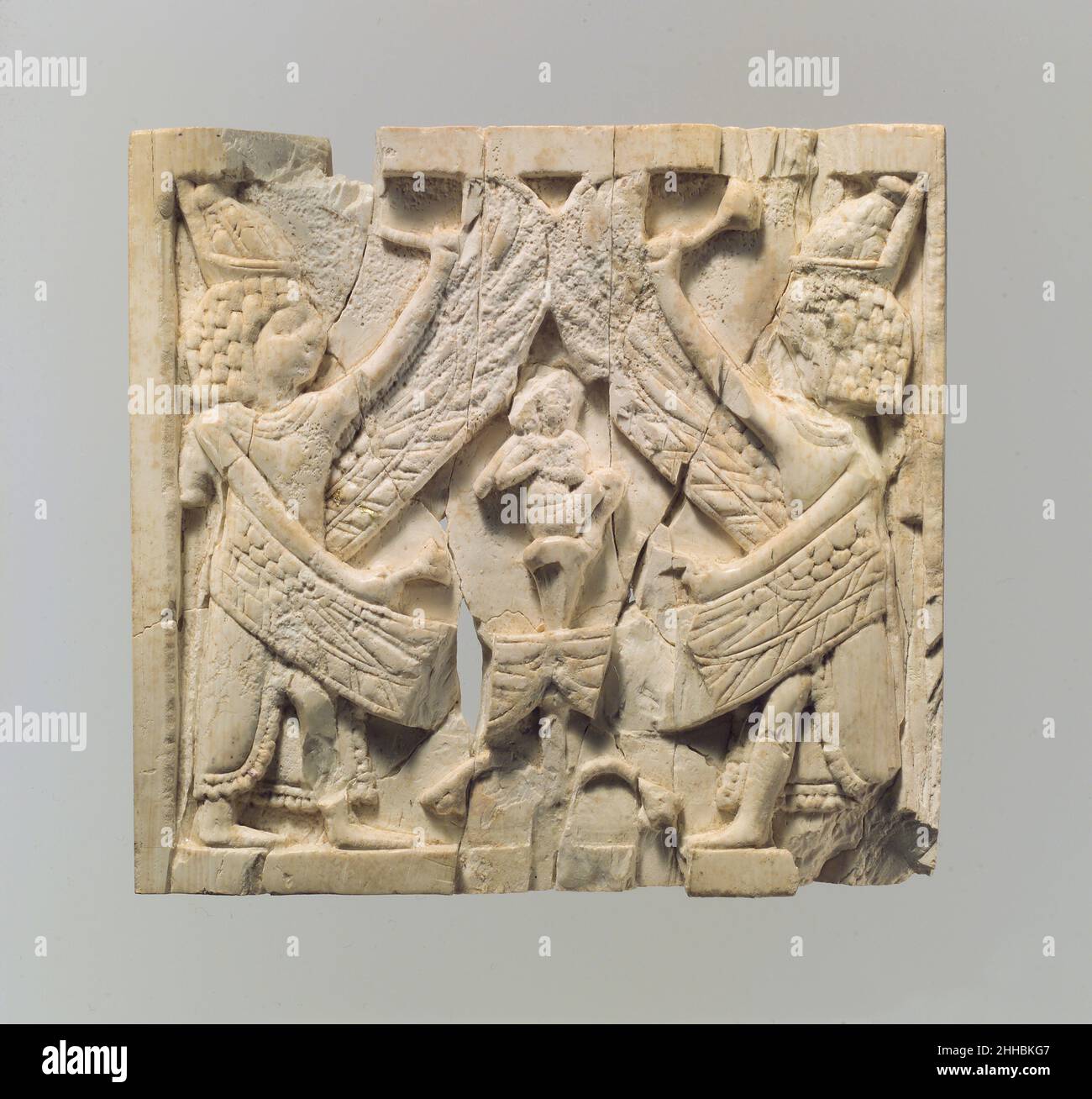 Furniture plaque carved in relief showing two winged, male figures ...