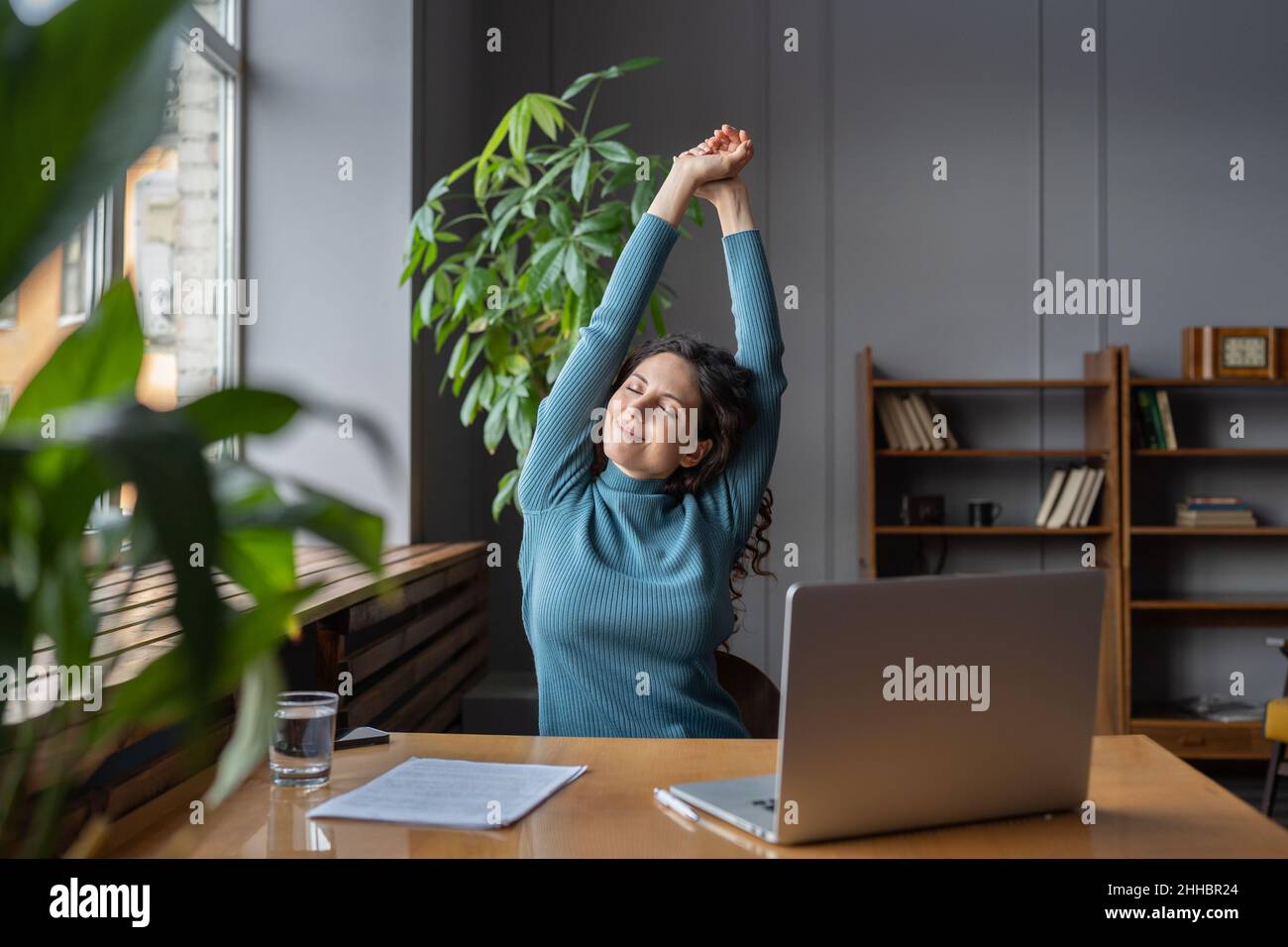 Happy business woman stretching at workplace, female employee resting ...