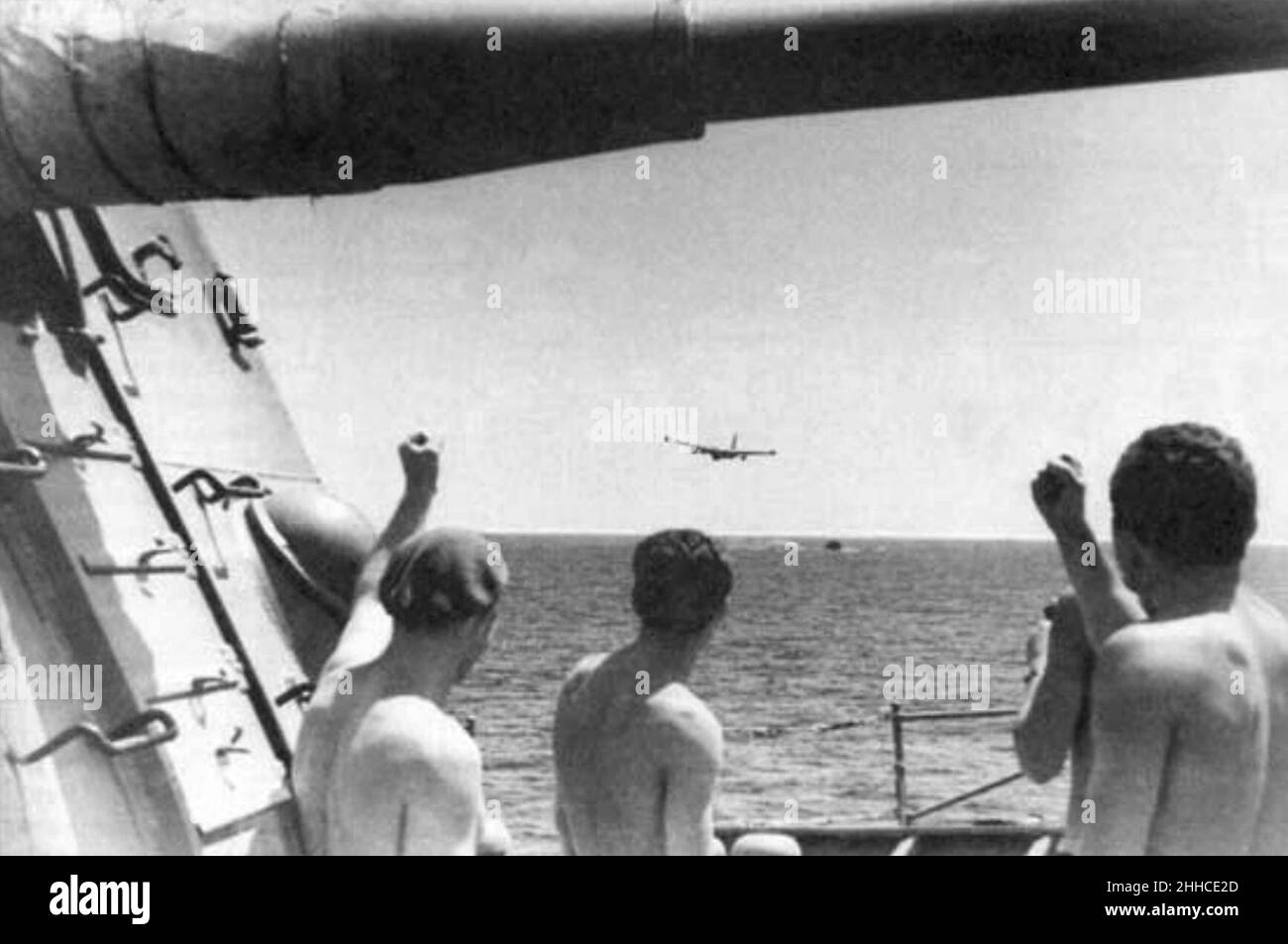 Soviet sailors shake their fists at a U.S. P2V Neptune flying over a ...