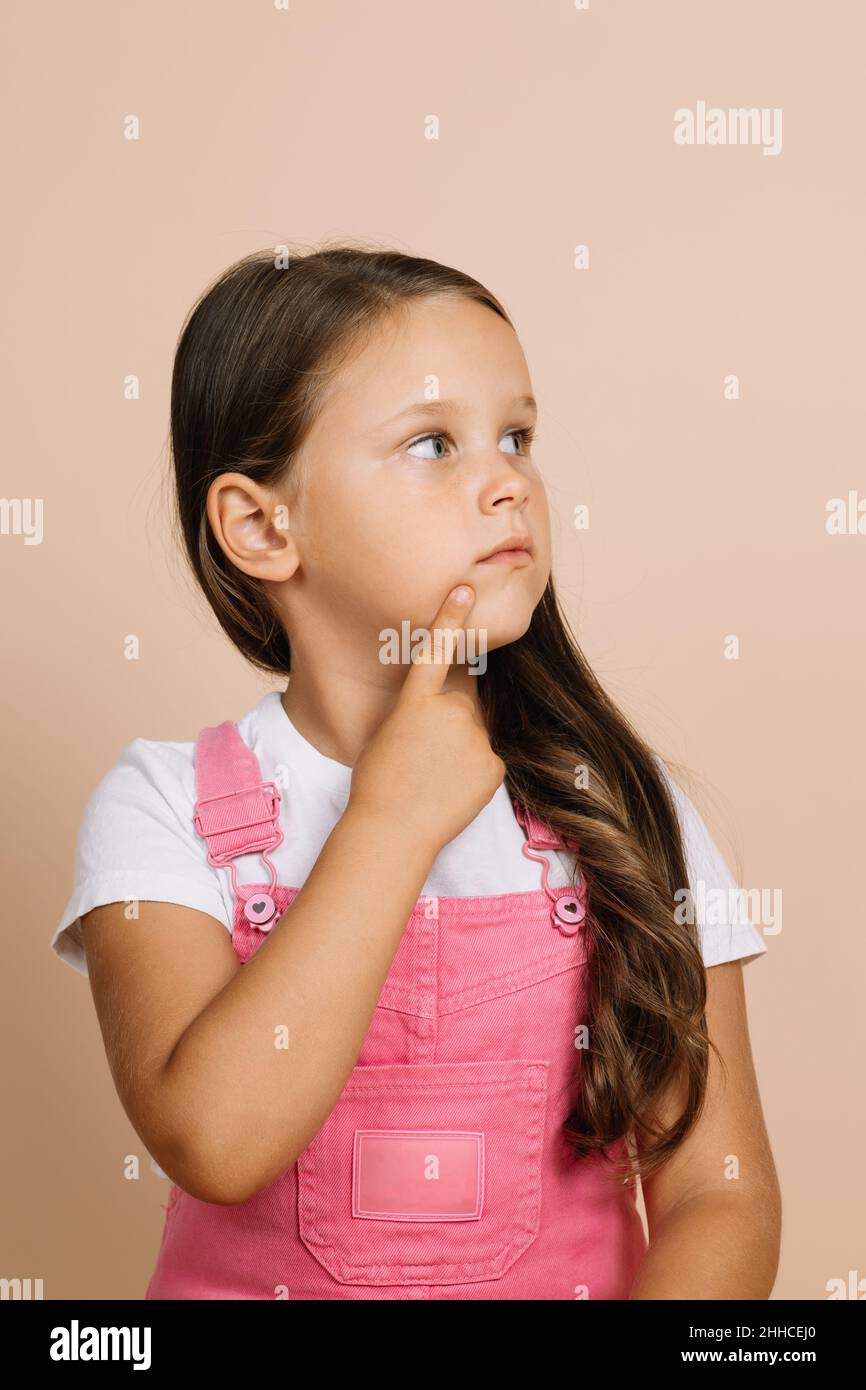 Portrait of child with shining bright eyes looking away, point finger ...