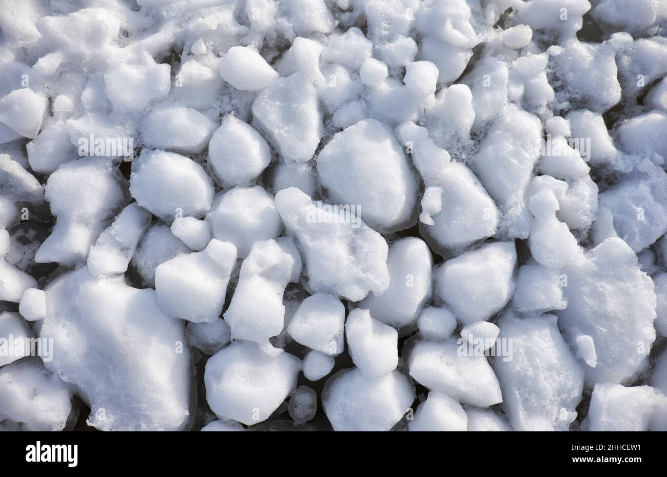 Lumps of snow and ice frazil on the surface of the freezing river water ...