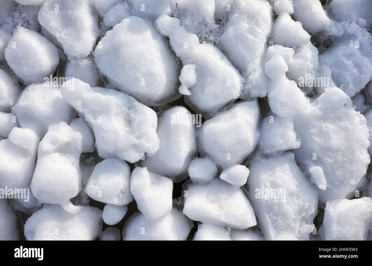 Lumps of snow and ice frazil on the surface of the freezing river water ...
