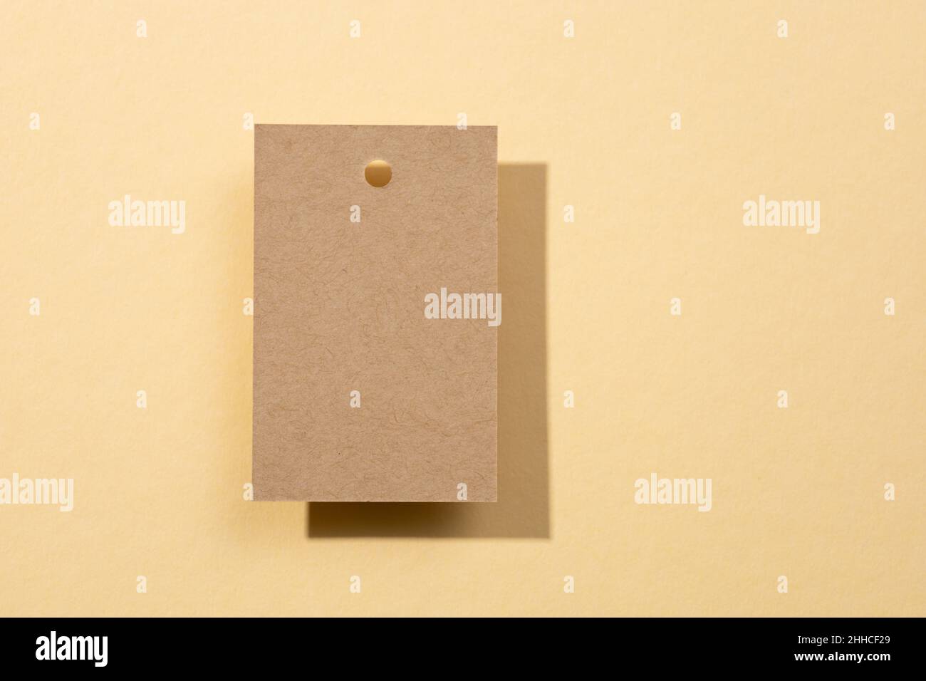 One blank cardboard label tag for clothes with tiny hole in upper part ...