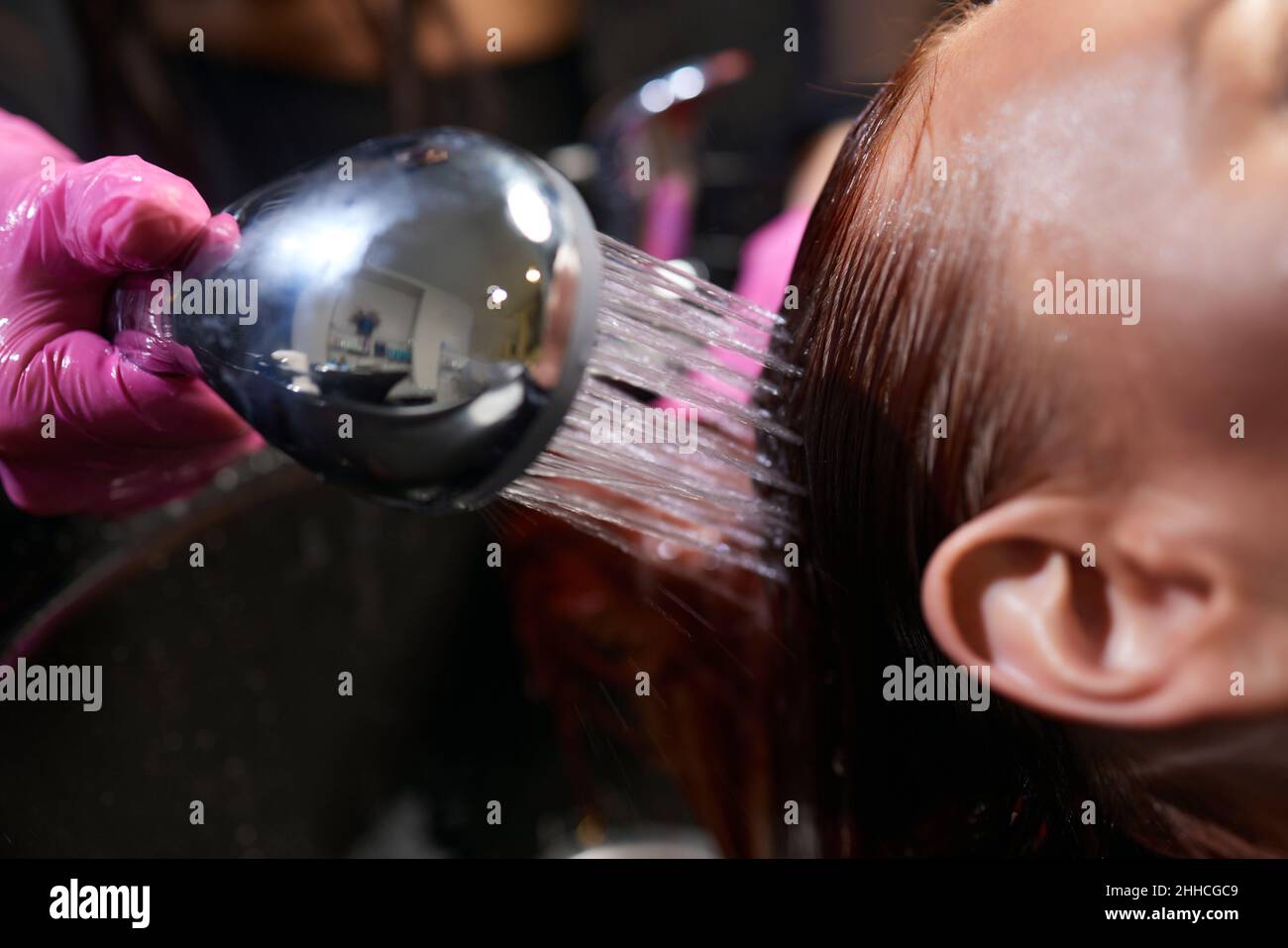 Hairdresser in beauty salon washes his client hair, before procedure of ...