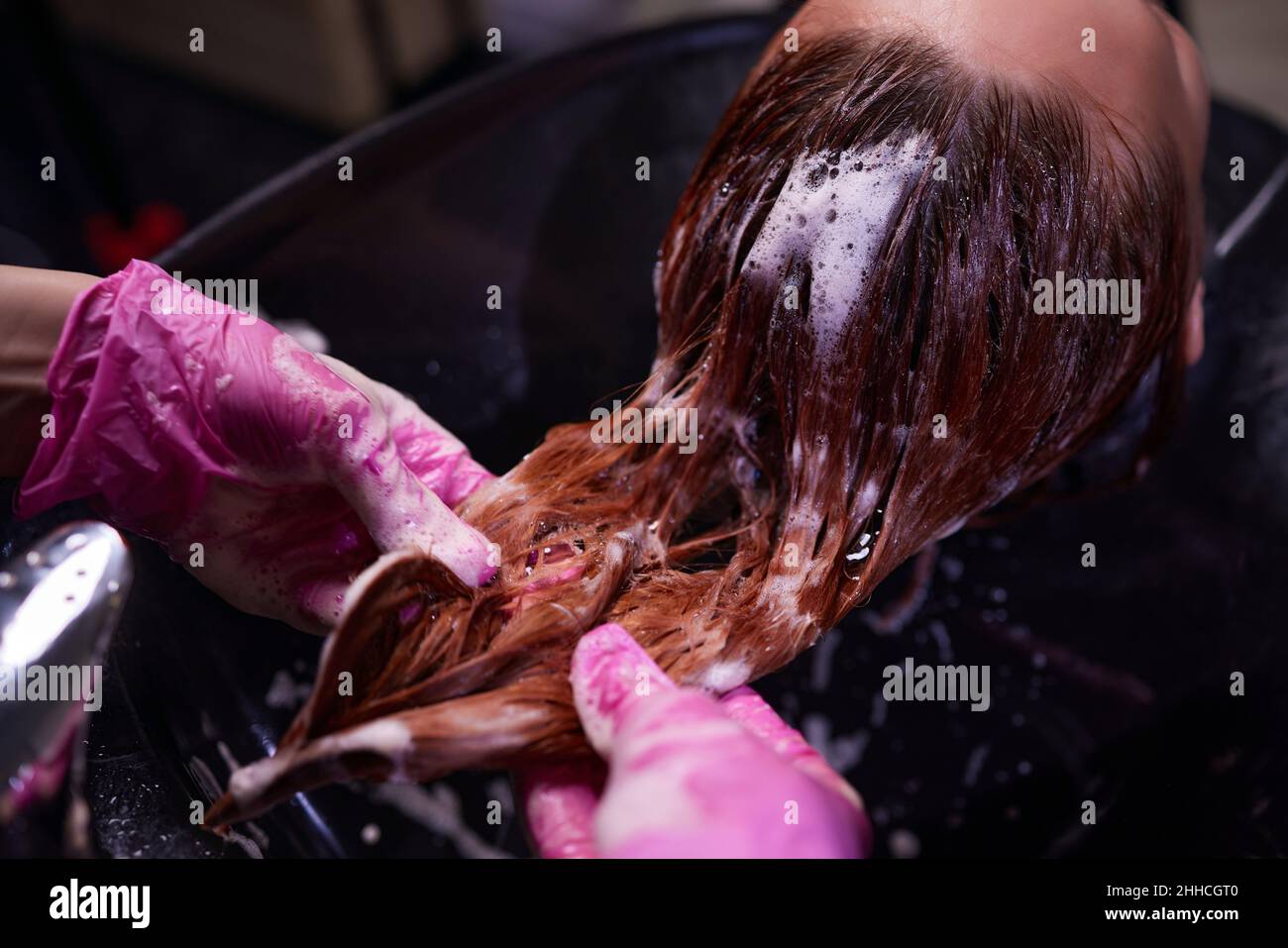 Hairdresser in beauty salon washes his client hair, before procedure of ...