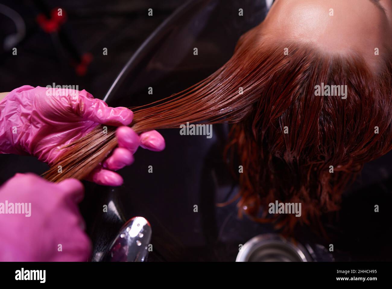 Hairdresser in beauty salon washes his client hair, before procedure of ...