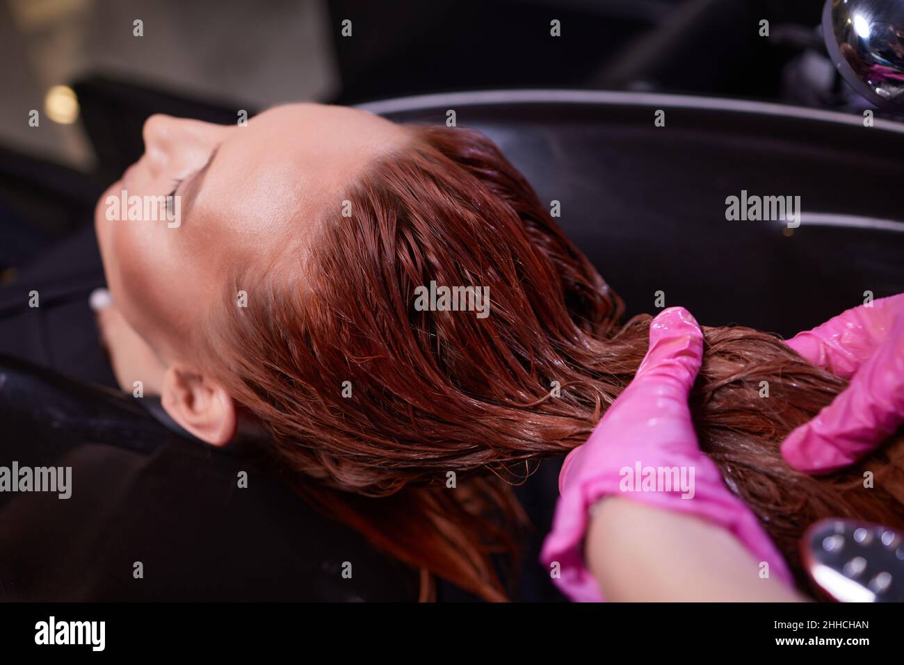 Hairdresser in beauty salon washes his client hair, before procedure of ...