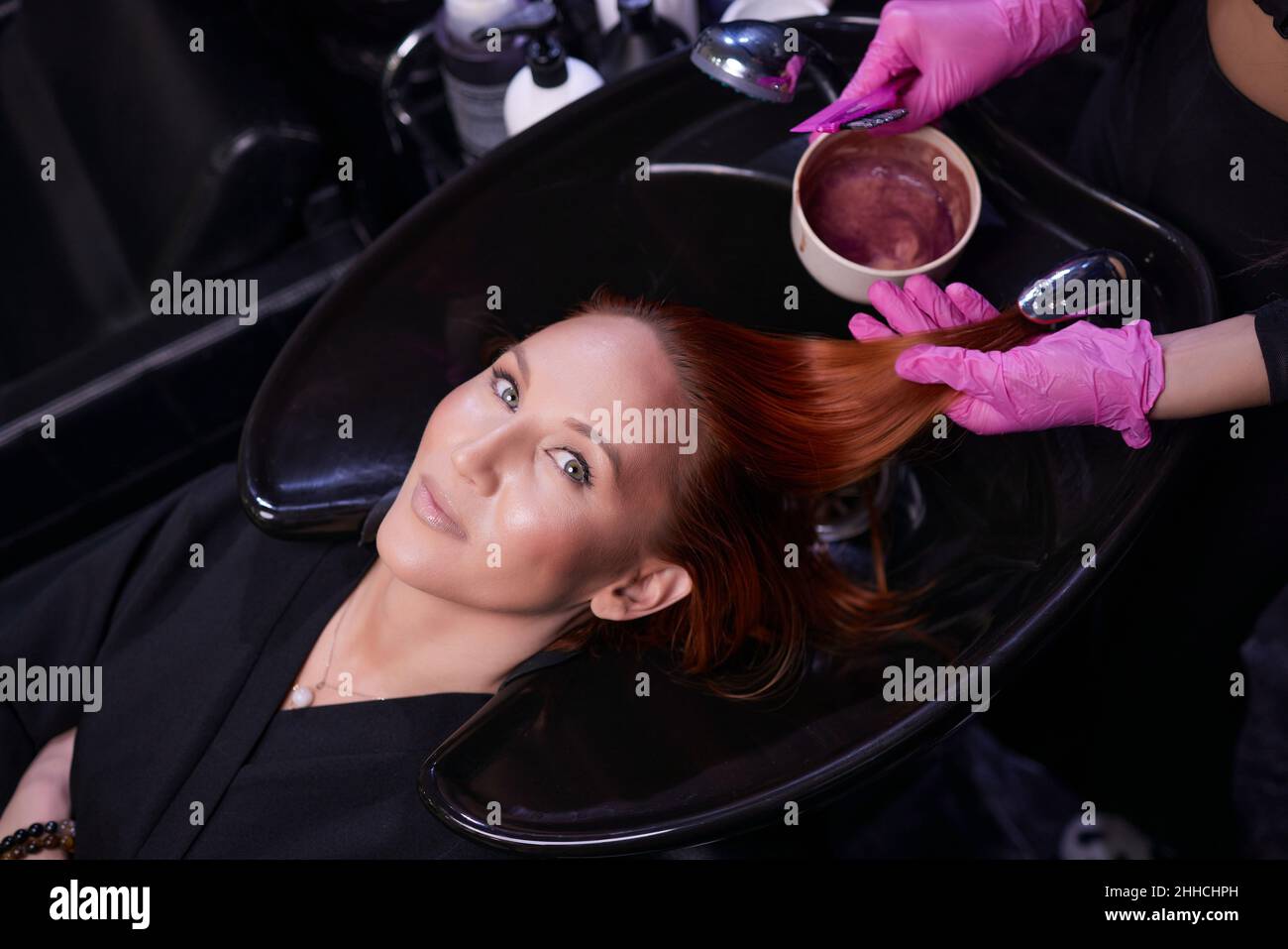 Hairdresser in beauty salon washes his client hair, before procedure of ...