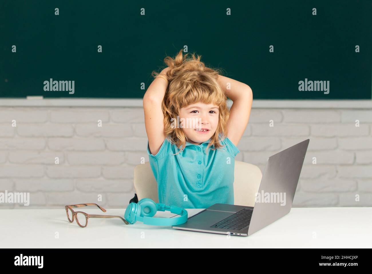 School boy learn lesson sitting at desk, studying online e-learning use ...