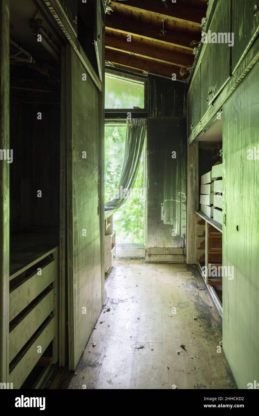 A fire damaged walk-in closet inside an abandoned house with blackened ...