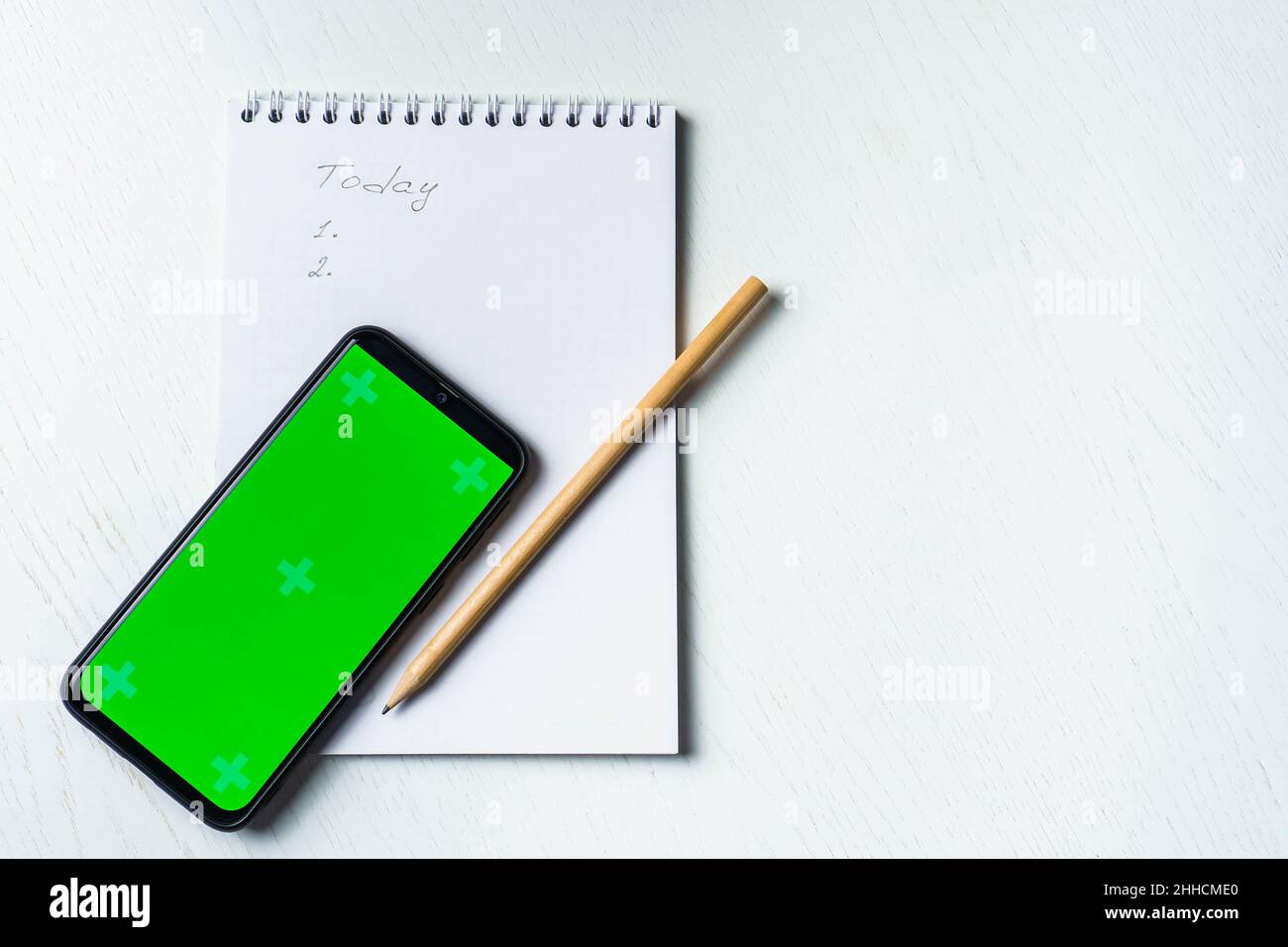 White notepad with inscription today, smartphone green screen mockup ...