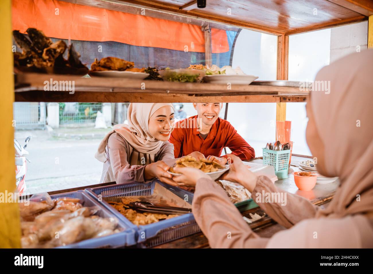 muslim couple sitting on traditional food stall, waiting for iftar time ...