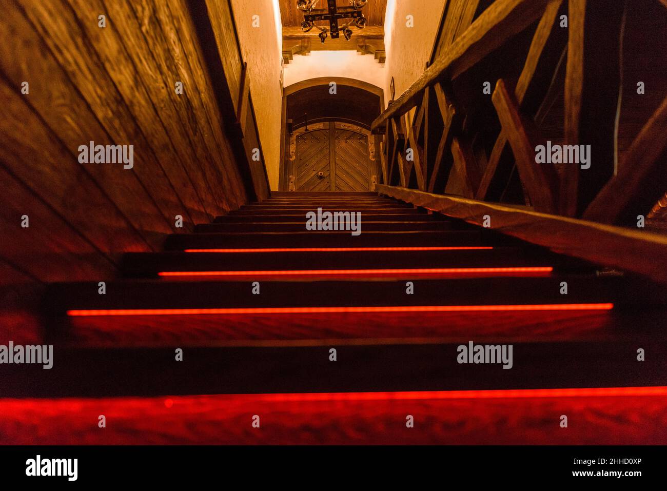Wooden steps of the stairs of the old cafe with red lighting under the ...